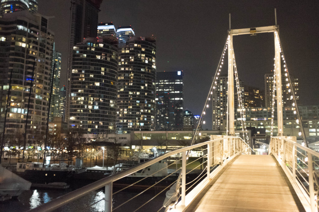 Lit waterfront bridge – a sibilant intake of breath